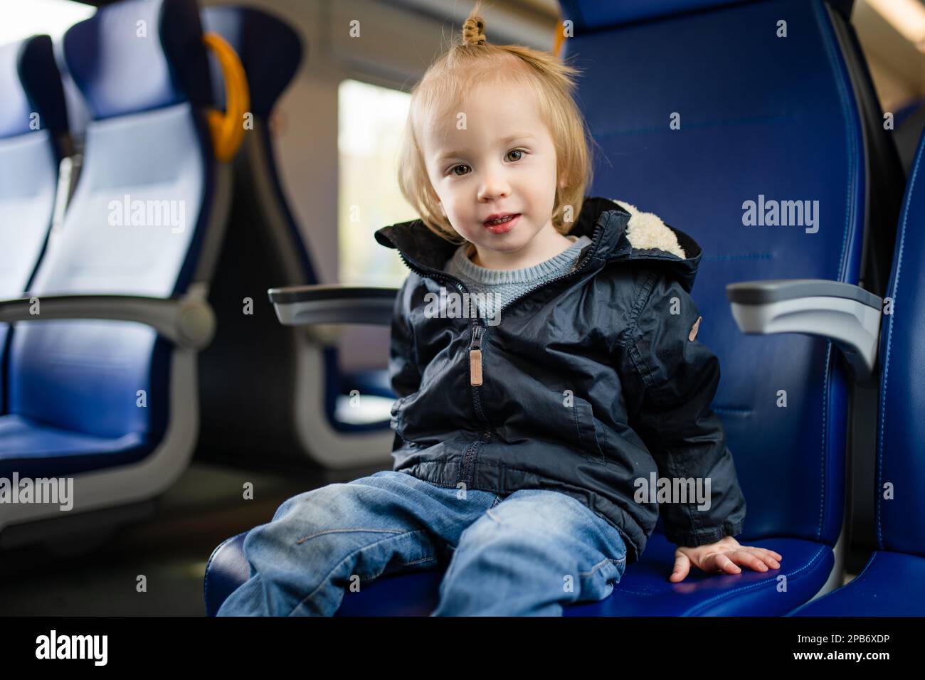 Toddler boy traveling by train. Little child sitting by the window in ...