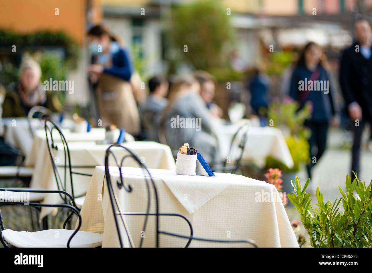 Empty outdoor restaurant tables in Varenna, one of the most picturesque ...