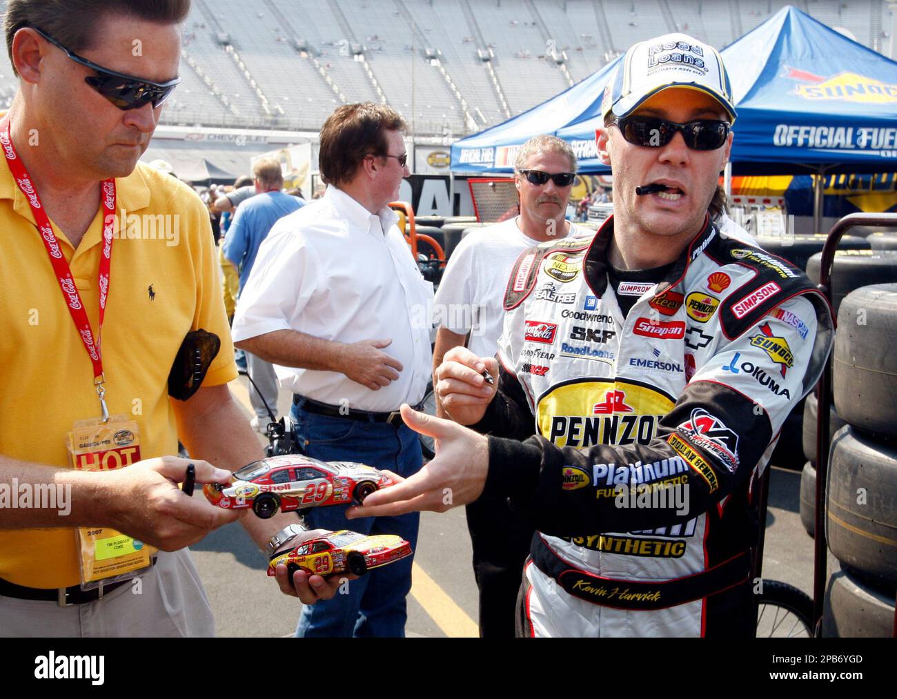 Kevin Harvick signs autographs as he walks through the infield at ...