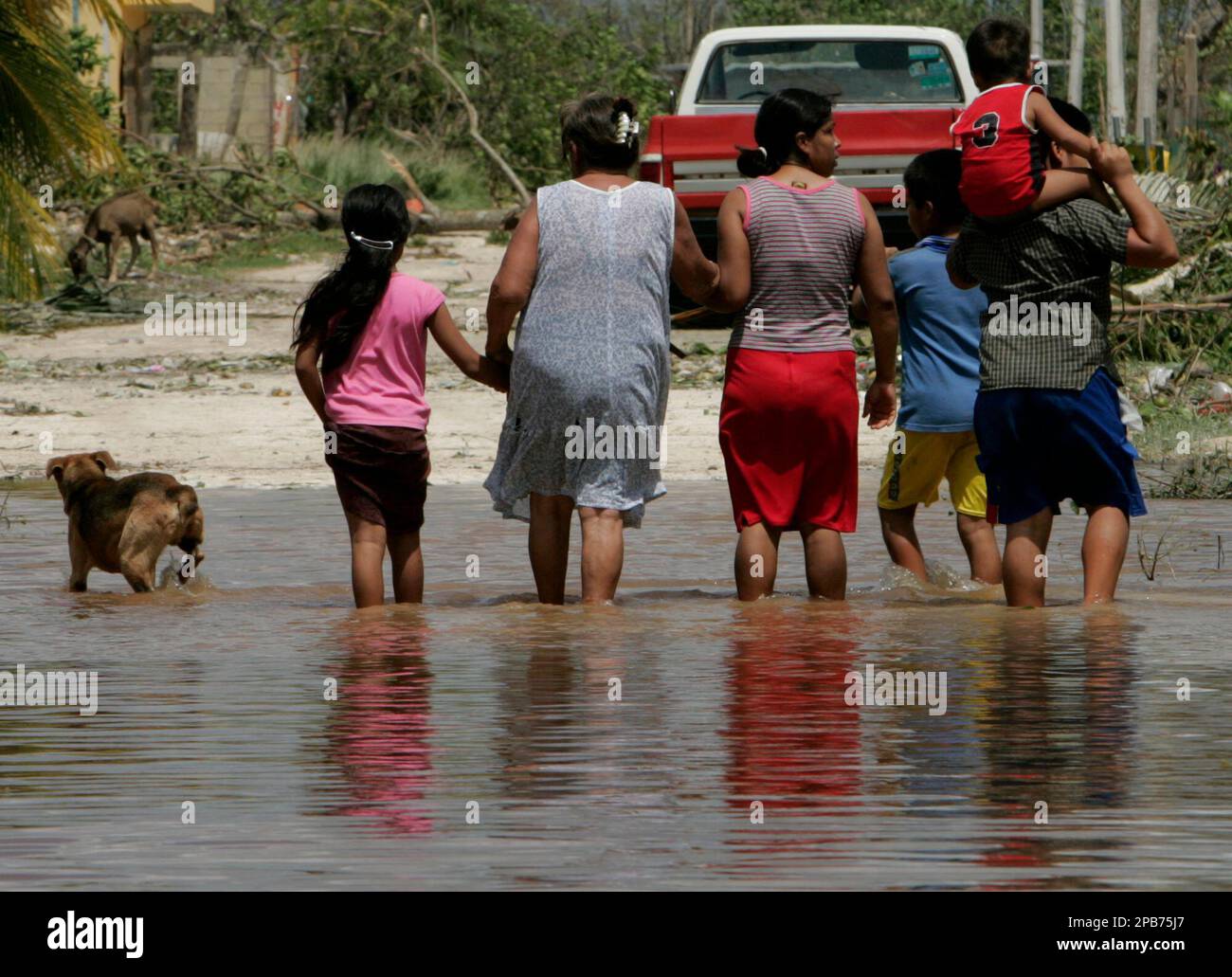 Residents walk through a flooded street in Bacalar, a day after the ...