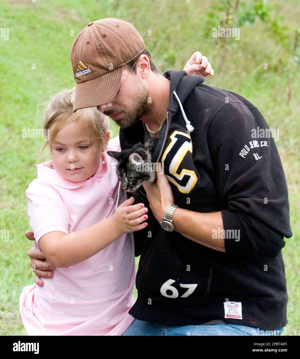 Jon Spitzer helps his daughter Caitlyn 5, and their cat, Blackie, after ...