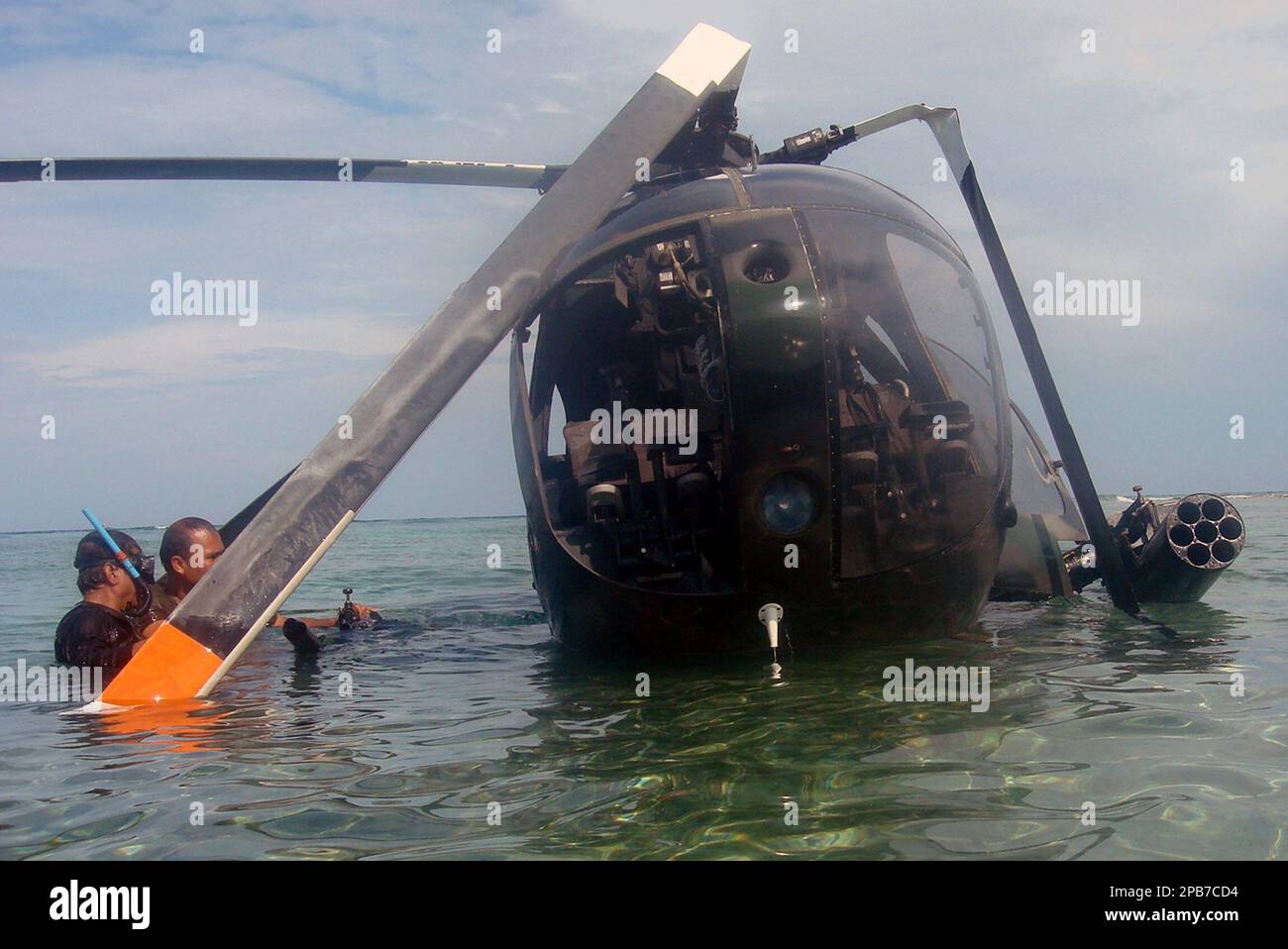 Philippine Navy personnel prepare to salvage a MG-520 attack helicopter ...