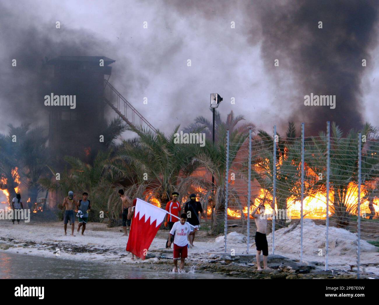 Unidentified local youths run after setting fire to a private ...