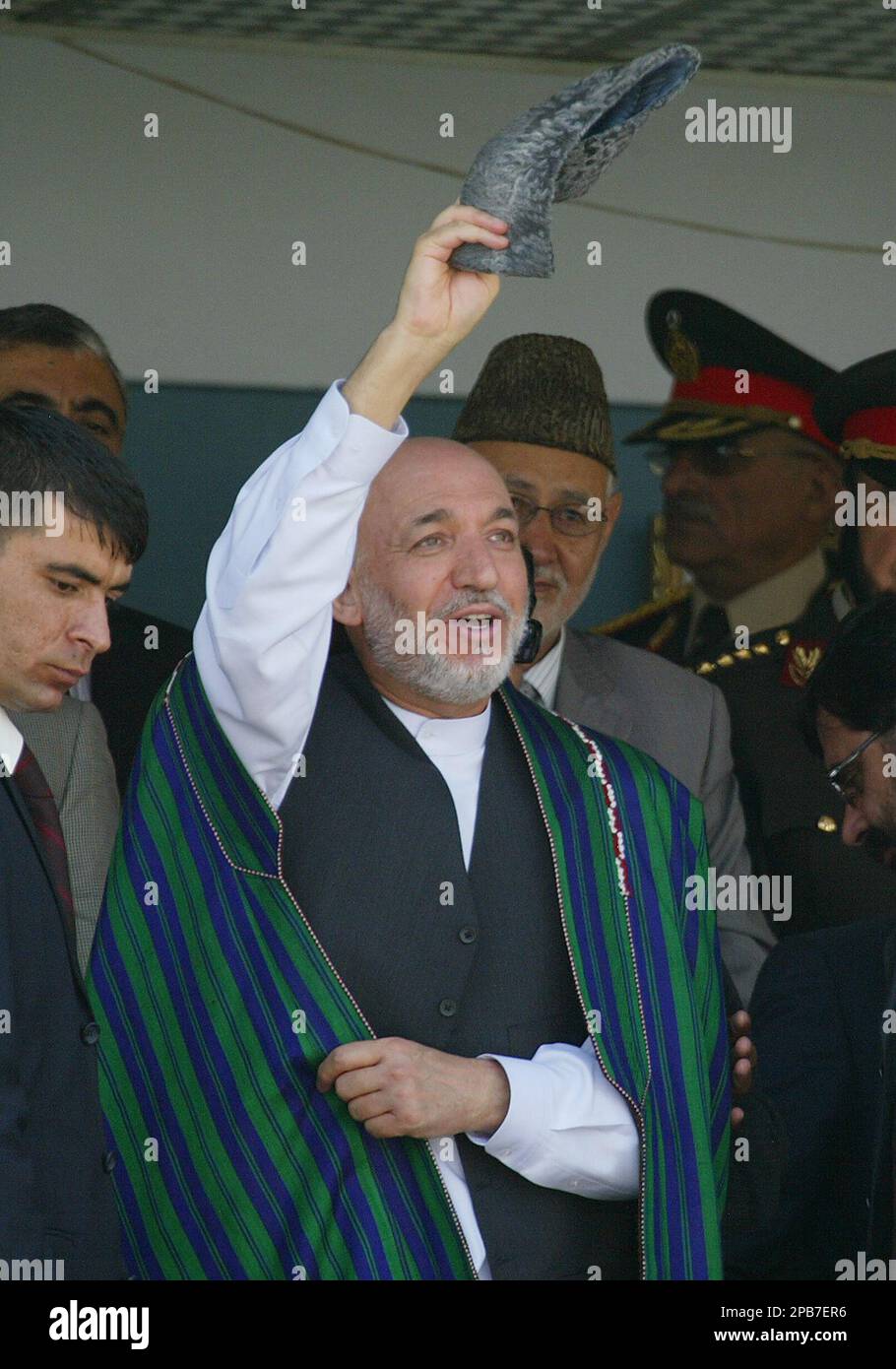 Afghan President Hamid Karzai takes off his cap as he greets the people ...