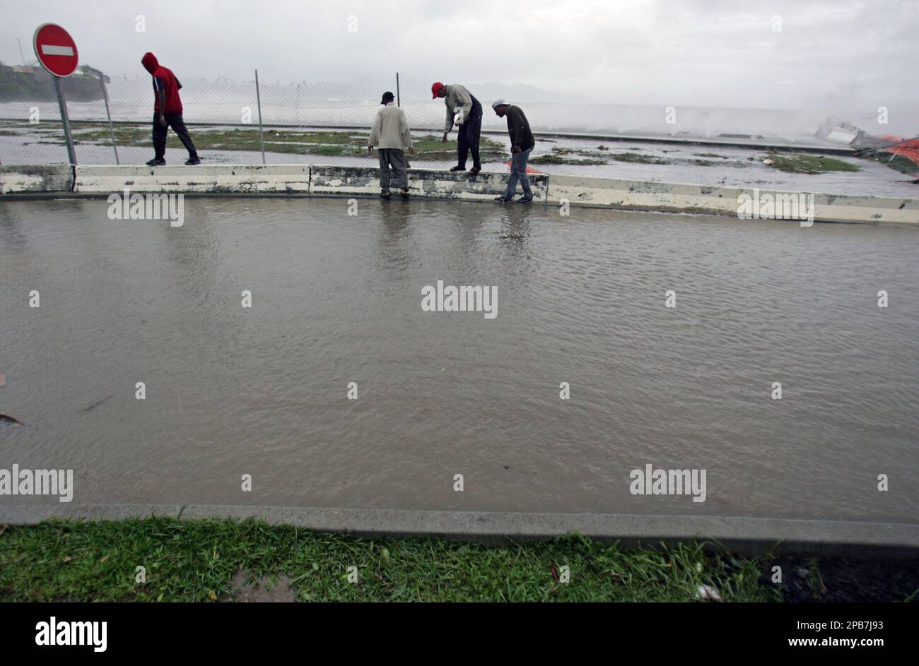 Men walk past an area of flooding near the waterfront, after Hurricane ...