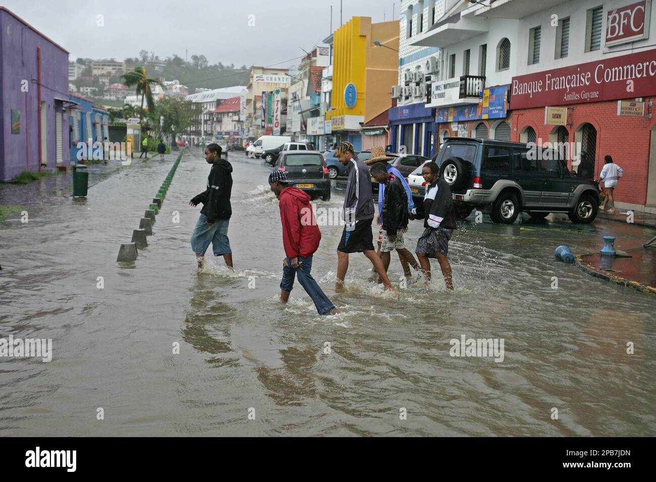 People walk through a flooded road, after Hurricane Dean hit Martinique ...