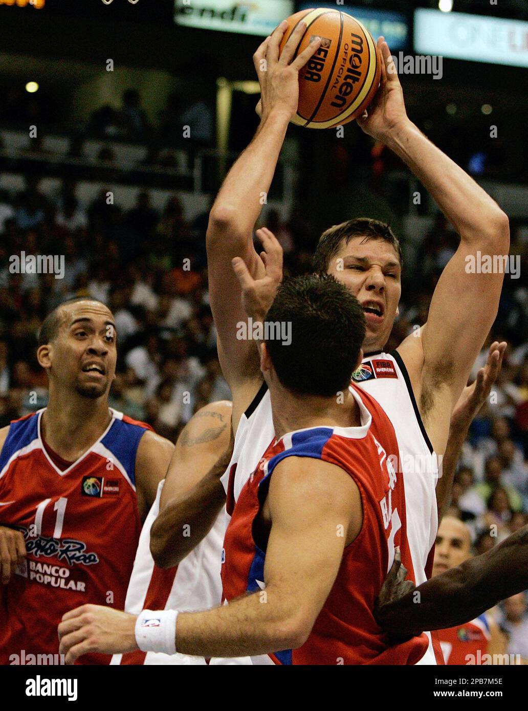 Canada's Jesse Young, right, reaches for a rebound as Puerto Rico's ...