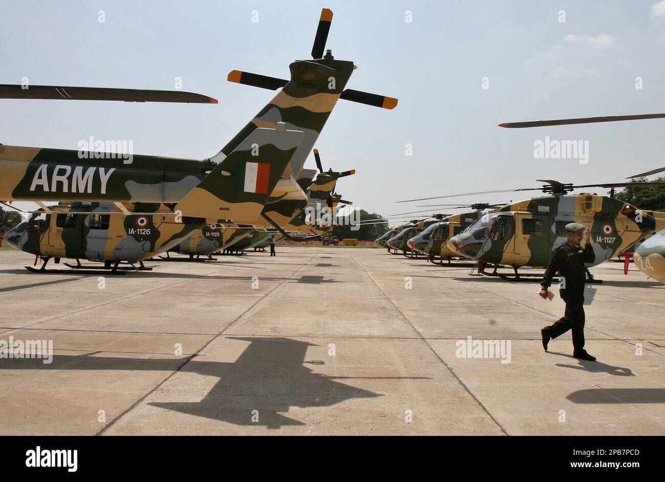 An official walks past the new version of Dhruv helicopters parked at ...