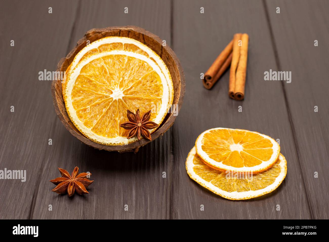 Star anise and dried orange slices in coconut shell. Cinnamon sticks on ...