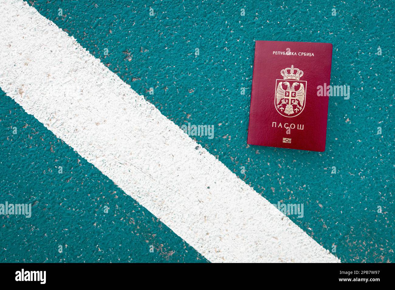 National Serbian passport next to a white line on the ground. Symbolic ...
