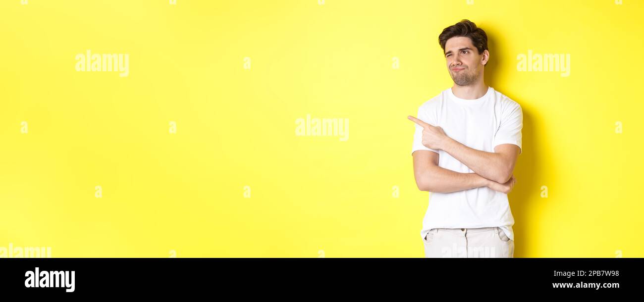 Unimpressed young man complaining, pointing and looking with skeptical ...