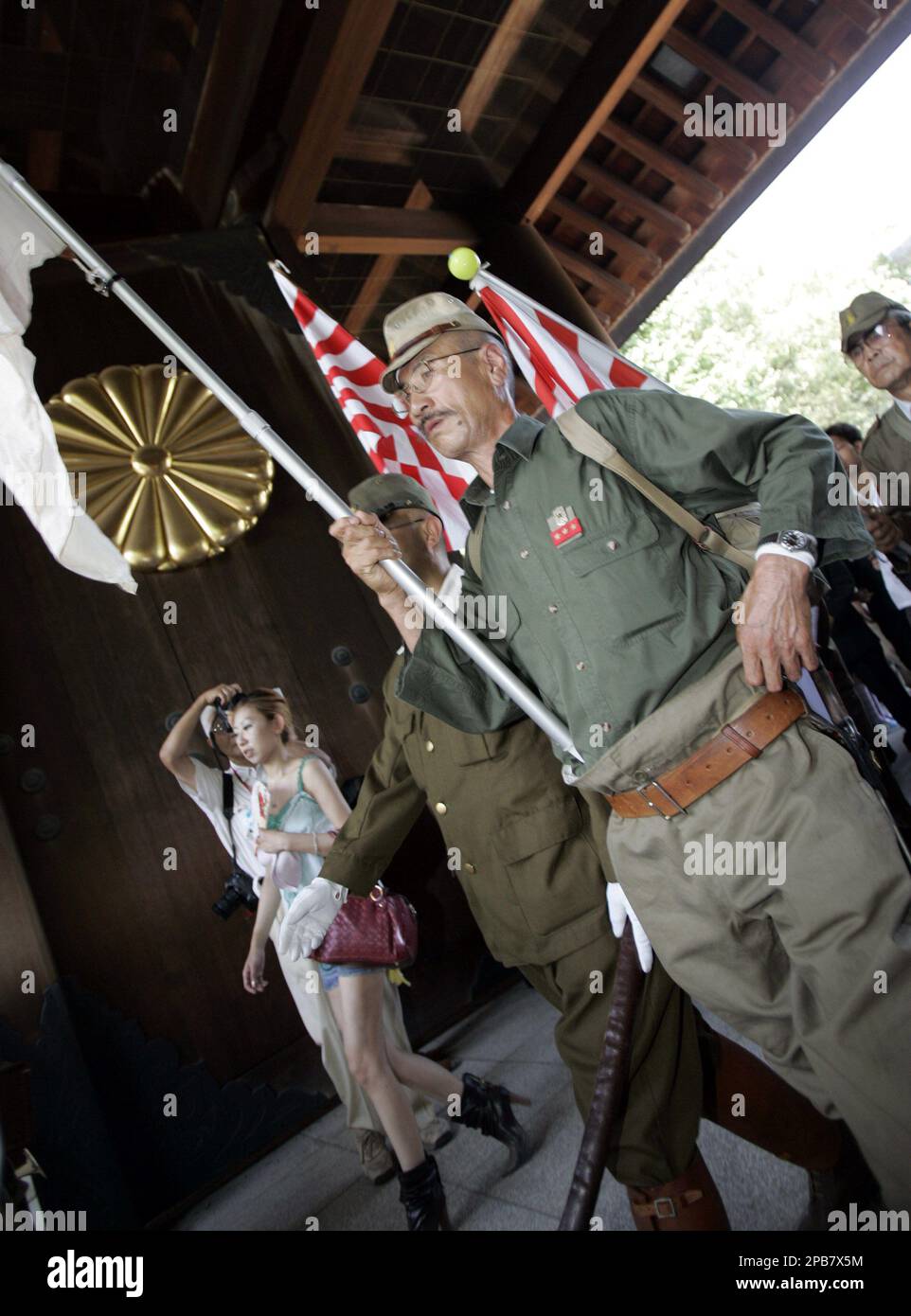 Japanese war veterans walk through the gate of the Yasukuni Shinto ...