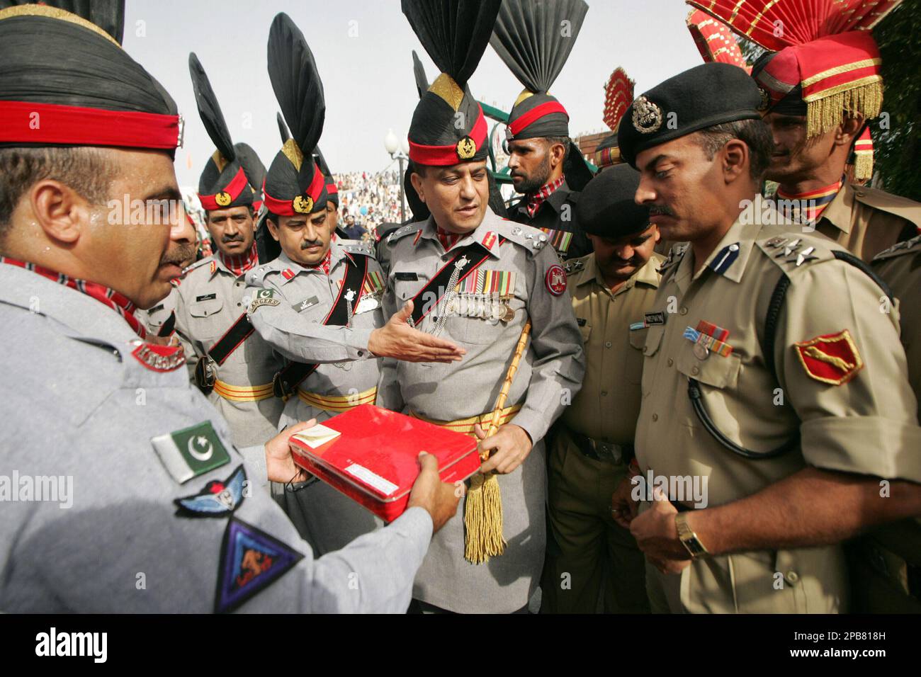 Pakistani Rangers officers, in gray uniform on left, offer a pack of ...