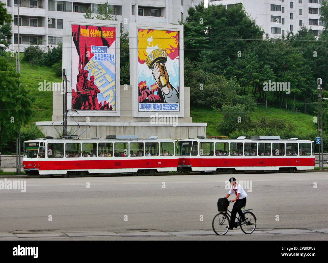 A North Korean boy cycles past a cable car in Pyongyang, North Korea ...
