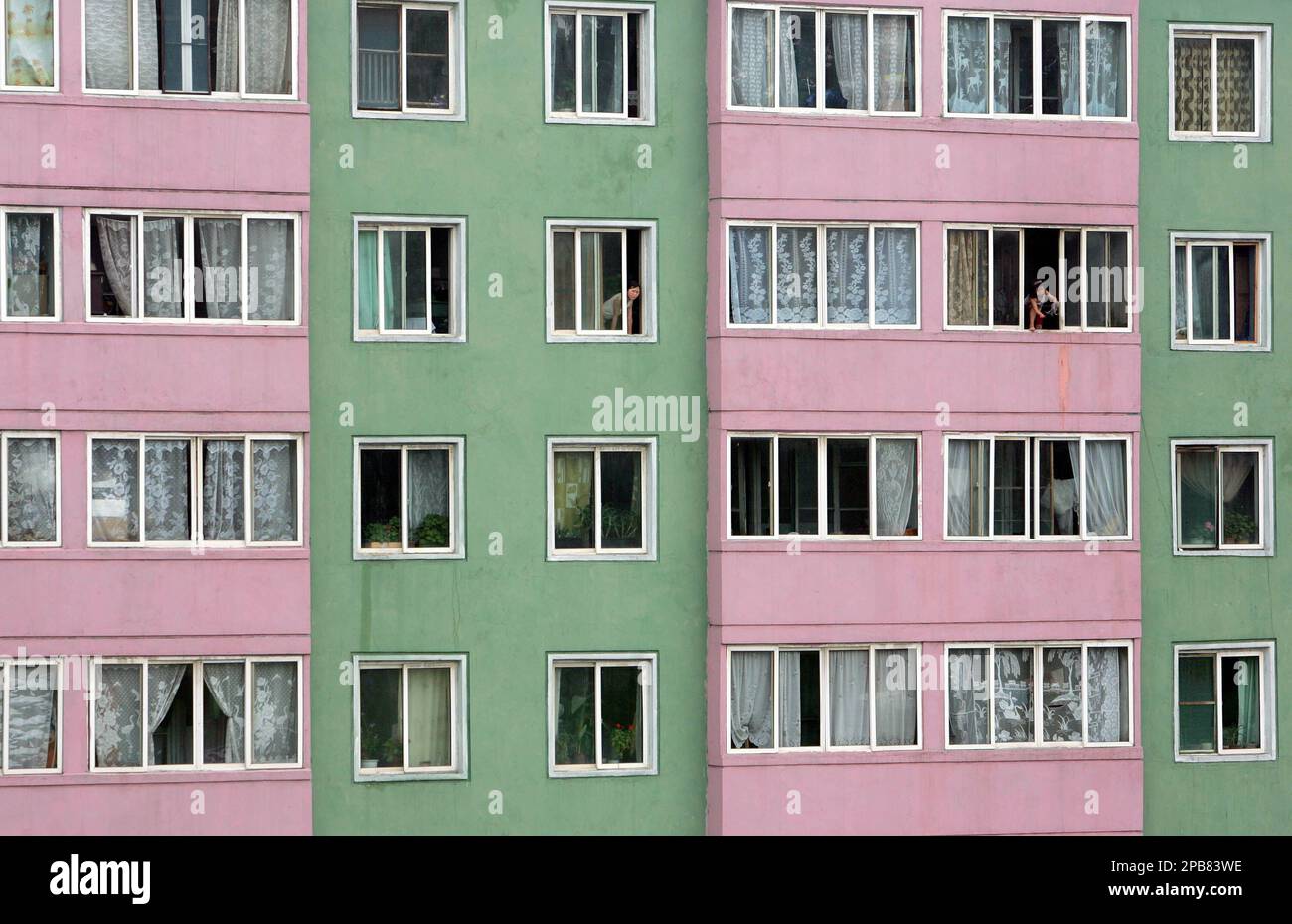 North Korean residents look out from their apartment complex in ...