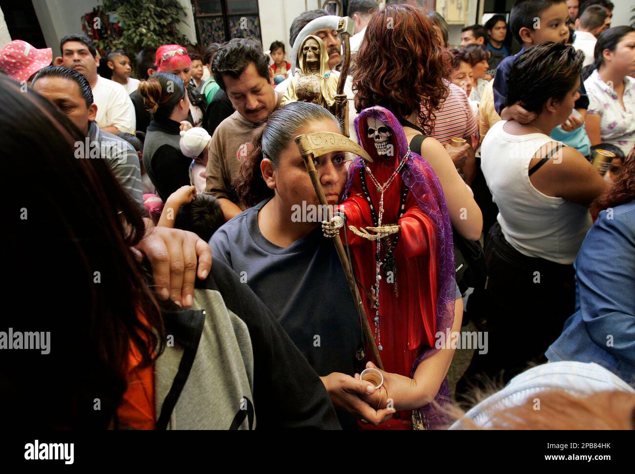 A woman holds a skeletal figure representing the folk saint known in ...