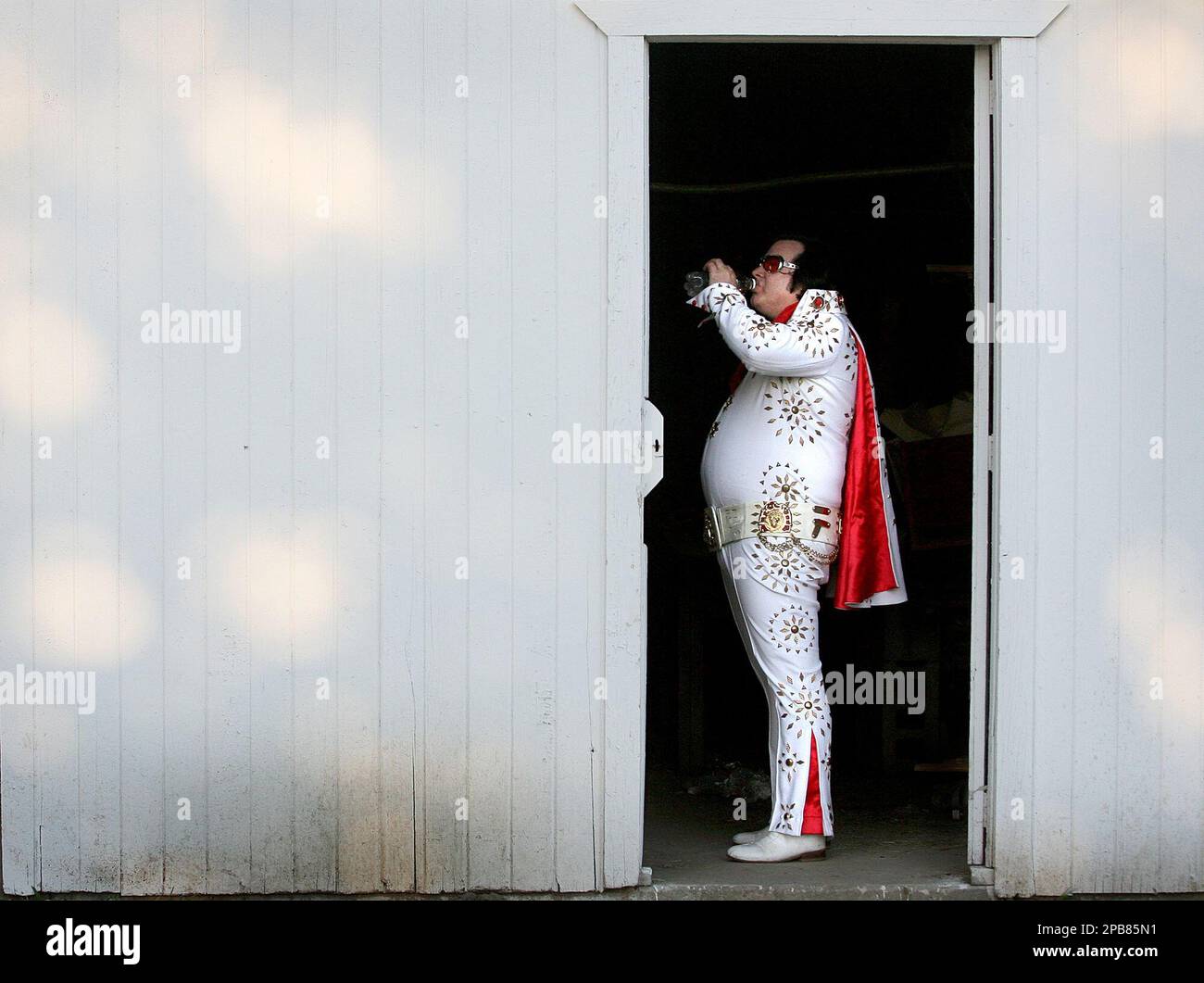 Performing as "Elvis Himselvis," Rick Dunham takes a drink of water ...