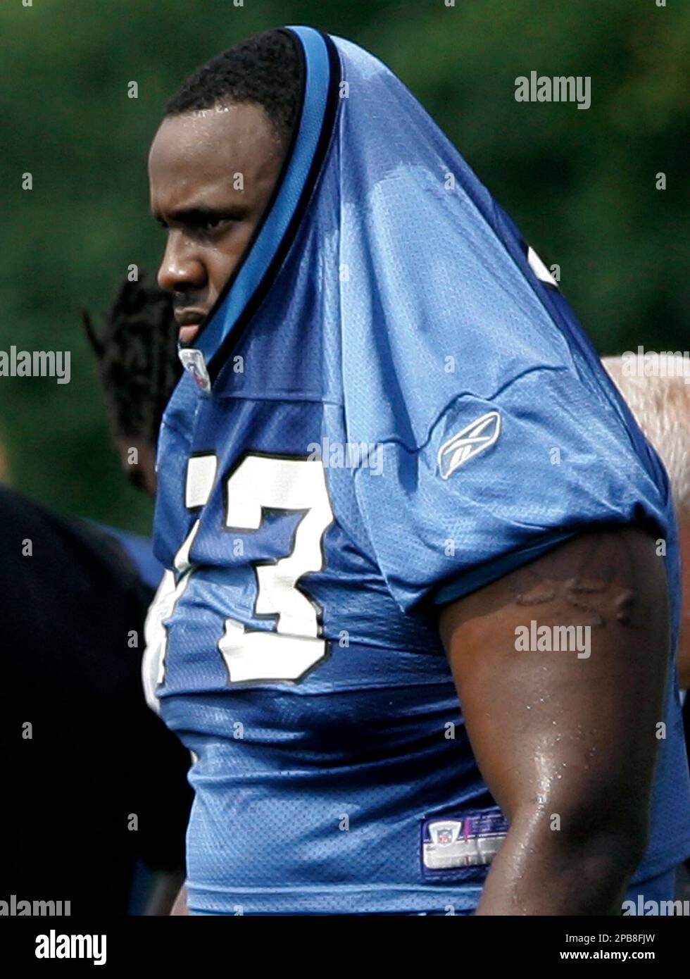 Detroit Lions offensive tackle Jonathan Scott pulls his jersey on his ...
