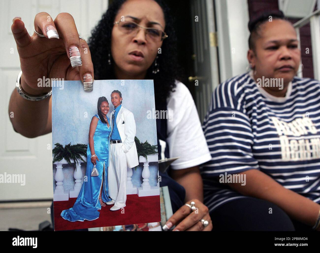 Family friend Cathy Rainey, left, holds up a 2006 photograph in Newark ...