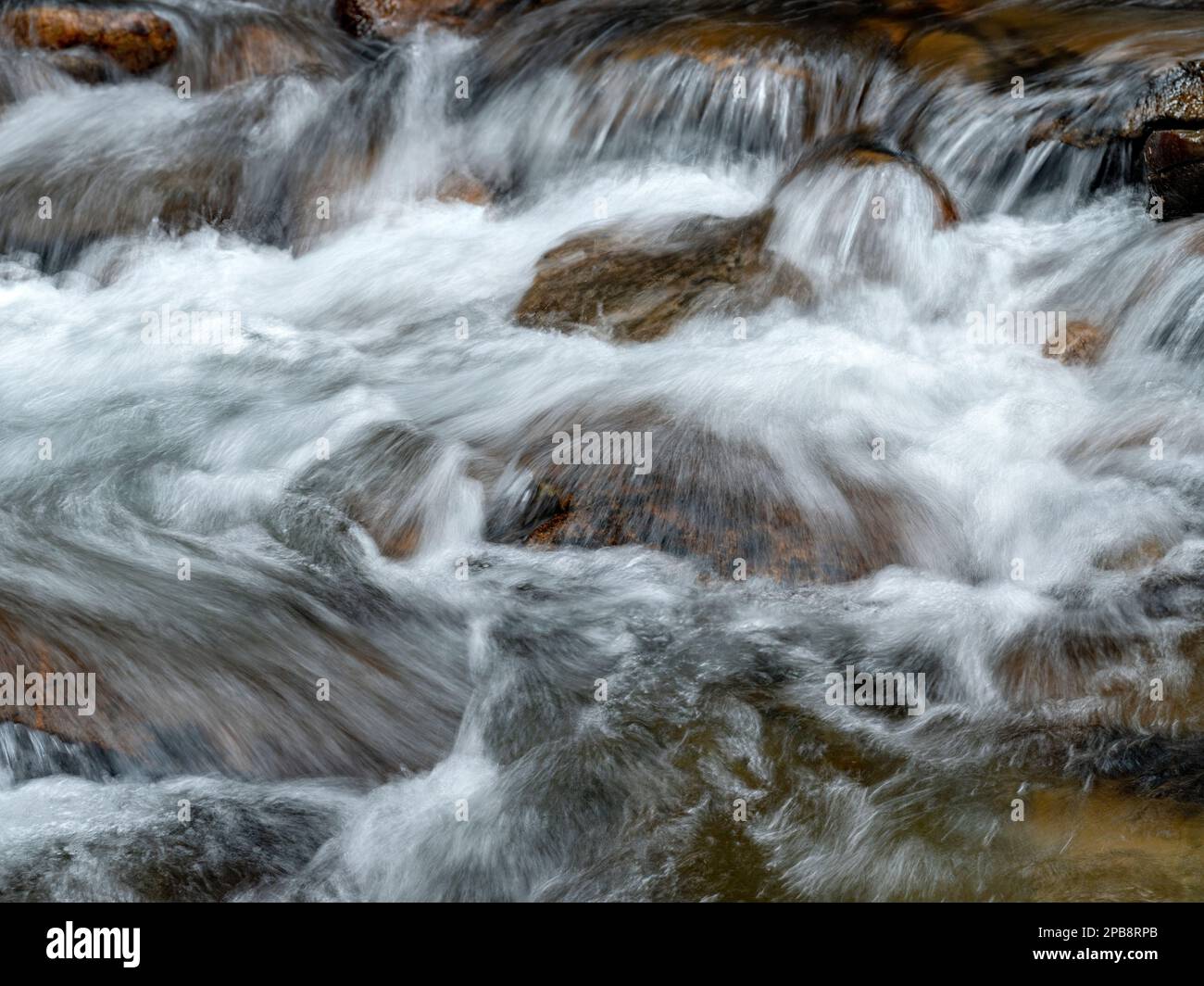 Cold water stream creating white water as it flows over rocks Stock ...
