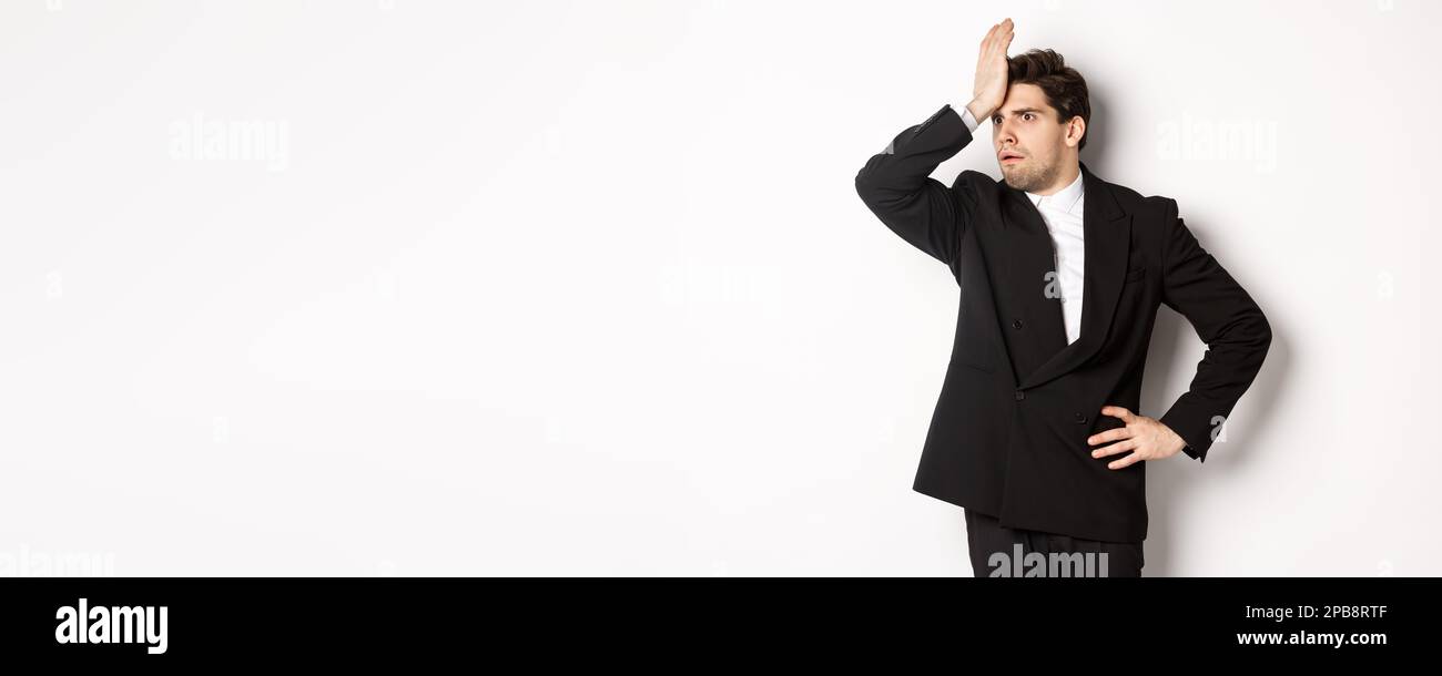 Portrait of shocked and distressed businessman in black suit, slap ...