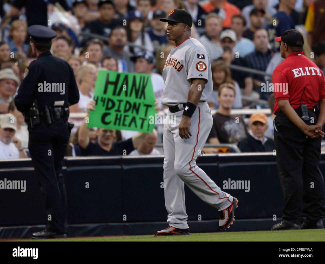 San Francisco Giants' Barry Bonds walks past a fan holding a protest ...