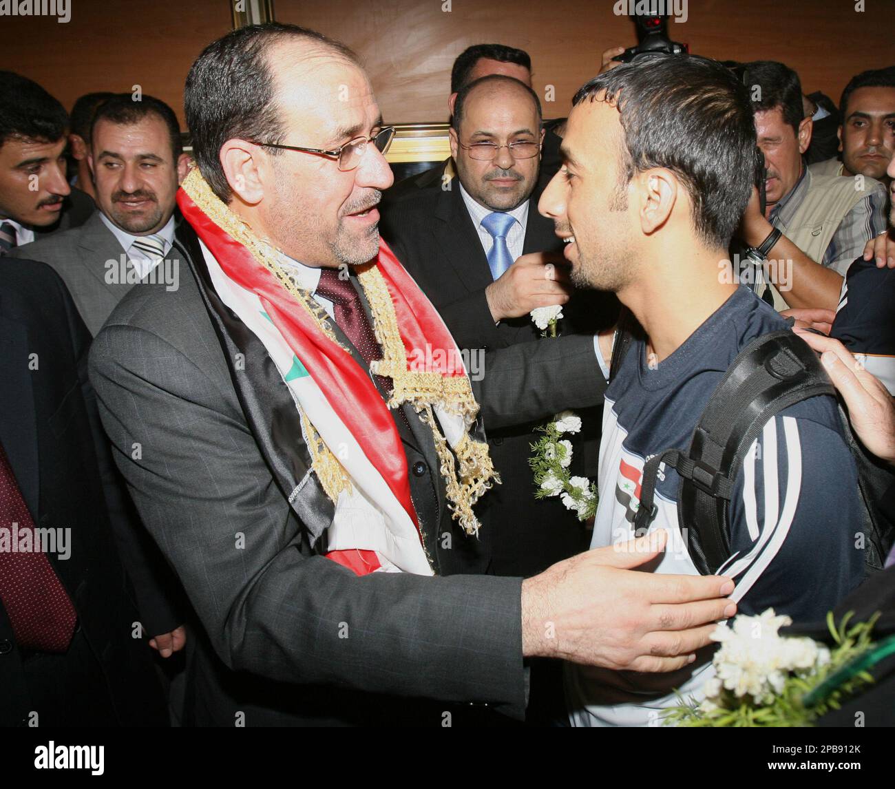 Iraq's Prime Minister Nouri al-Maliki, left, embraces Asian Cup soccer ...