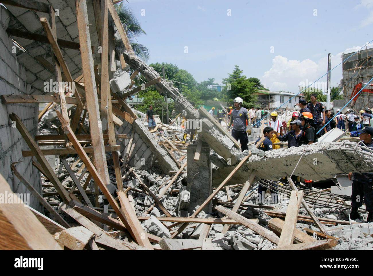 Rescuers survey the extent of the damage after a concrete wall of a ...