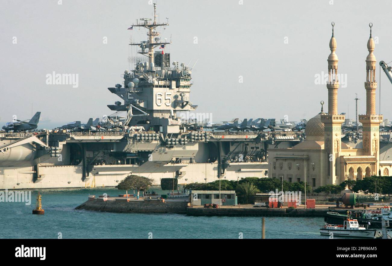 The USS Enterprise passes behind a mosque as it makes its way through ...