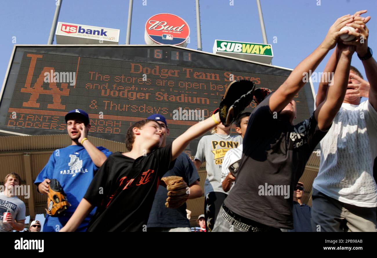 San Francisco Giants fan Logan Adams competes for a fly ball with Los ...