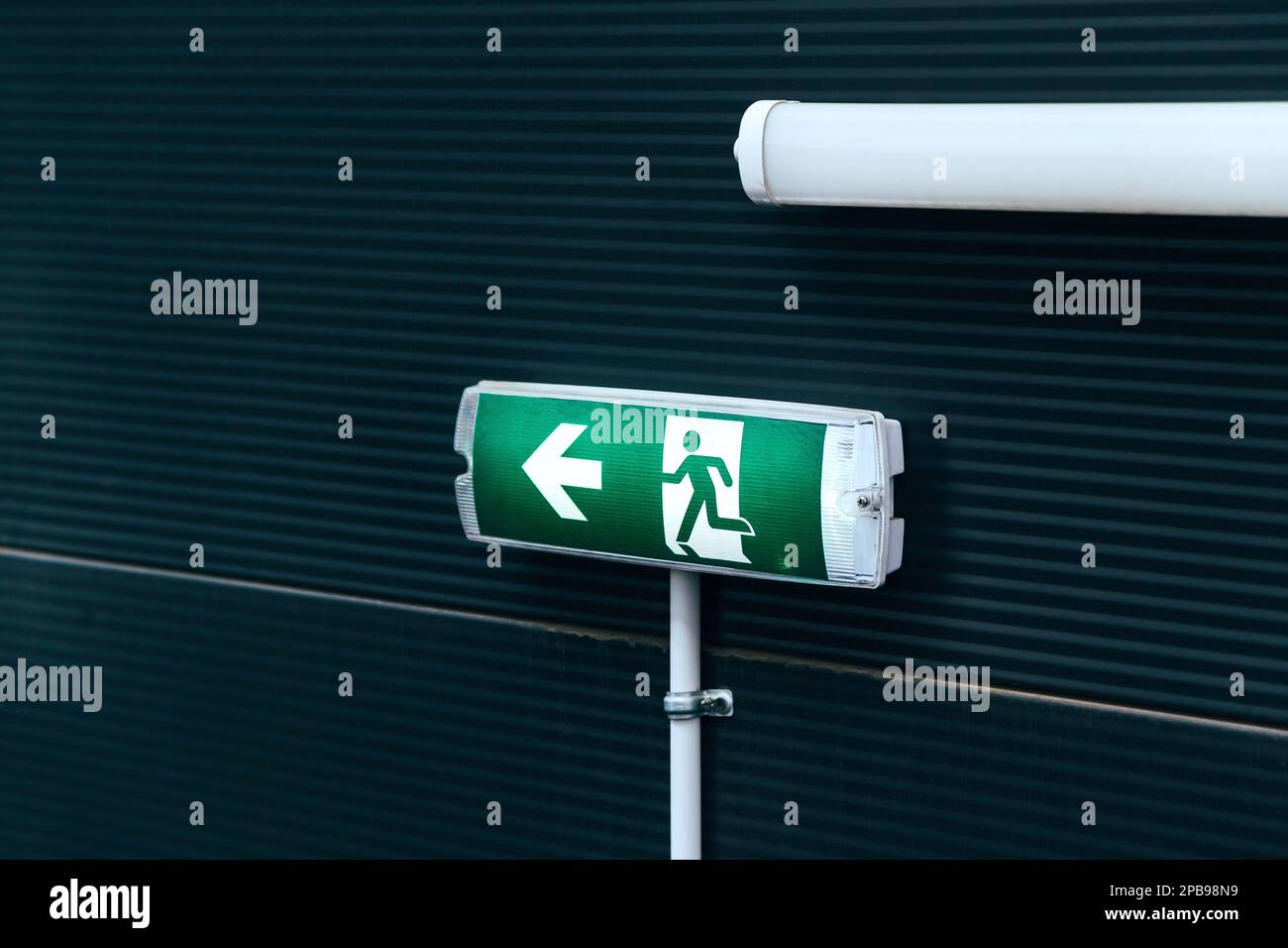 Emergency exit green sign on wall at emergency stairs at shopping ...