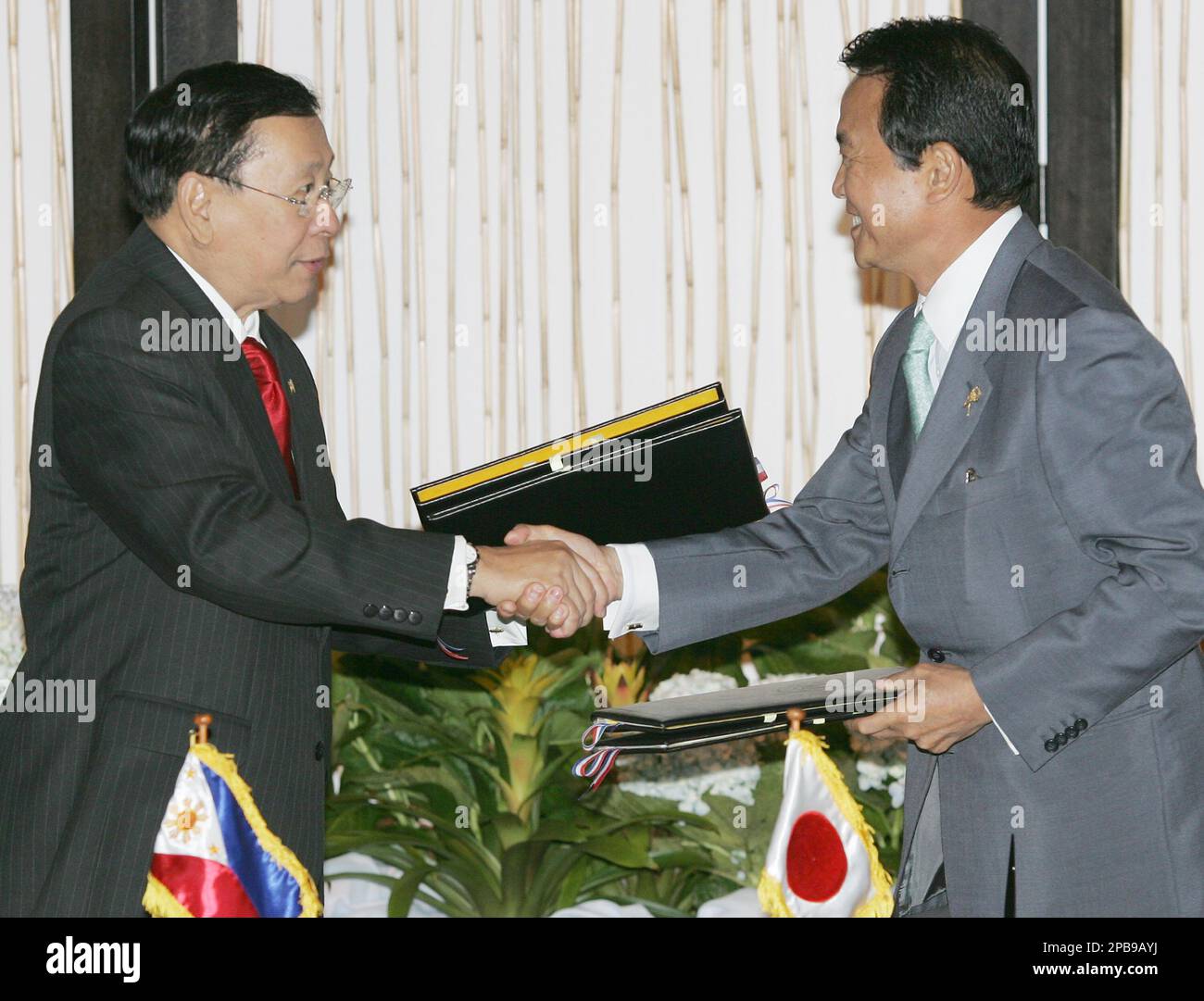 Philippine Foreign Affairs secretary Alberto Romulo, left, exchanges ...