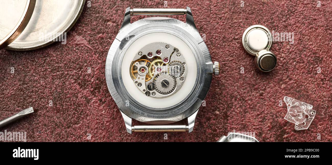 Broken watch on brown background Stock Photo - Alamy