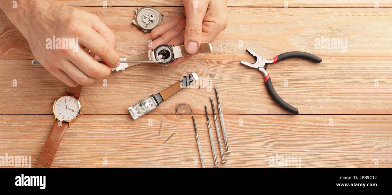 Male clock maker repairing broken watches at table Stock Photo - Alamy