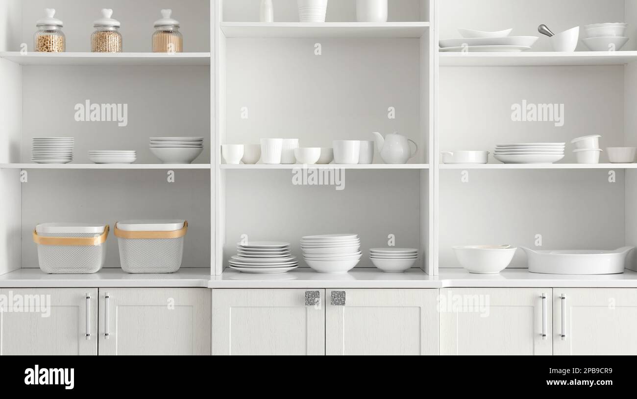 Open cupboard with clean dishes in kitchen Stock Photo - Alamy