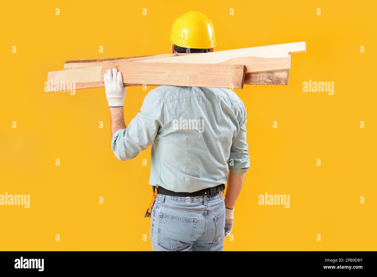 Male carpenter with wooden planks on yellow background, back view Stock ...