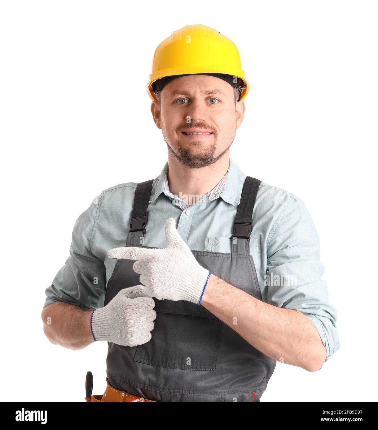 Male carpenter in hardhat pointing at something on white background ...