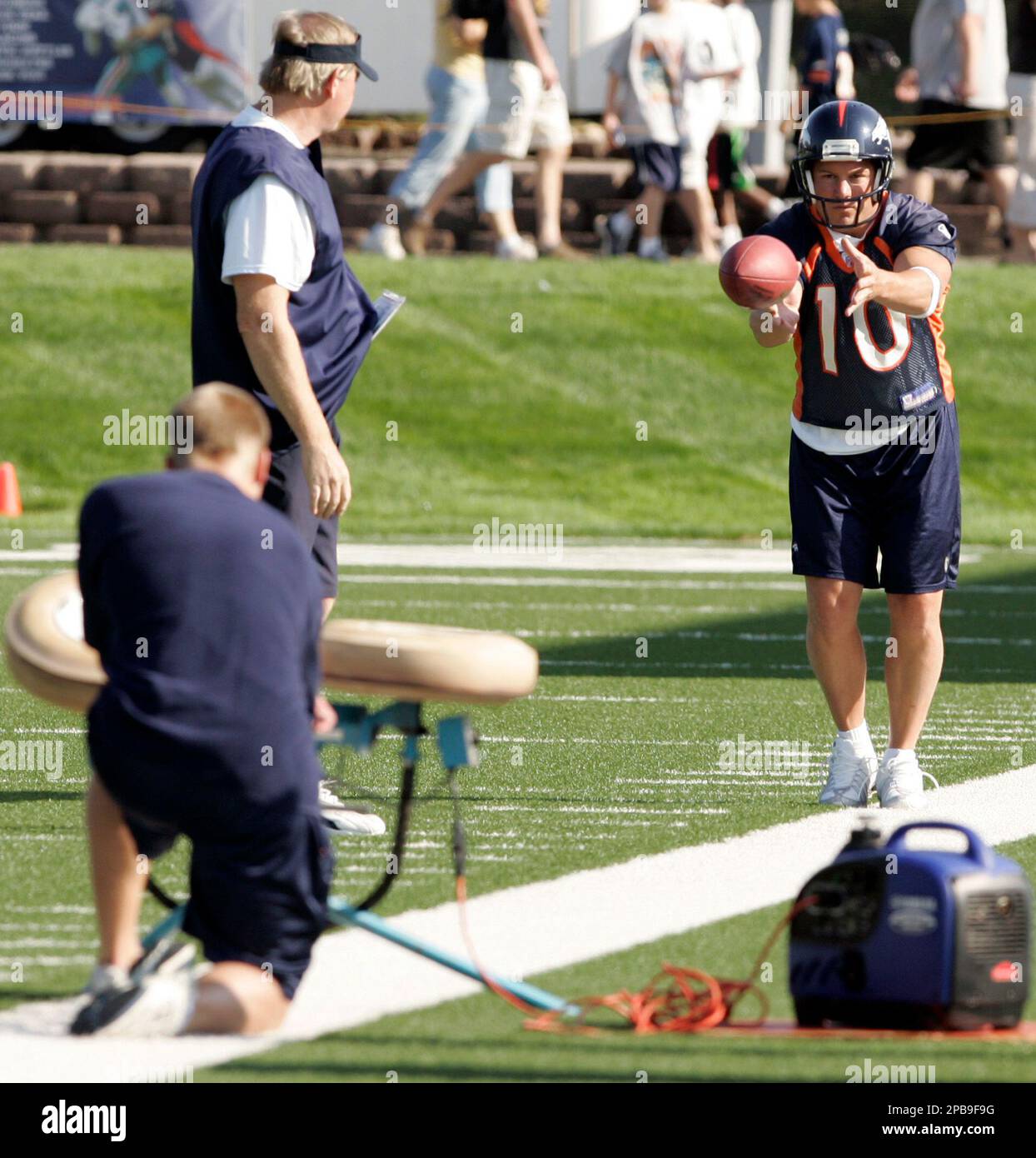 Denver Broncos punter Todd Sauerbrun takes a snap from a machine during ...