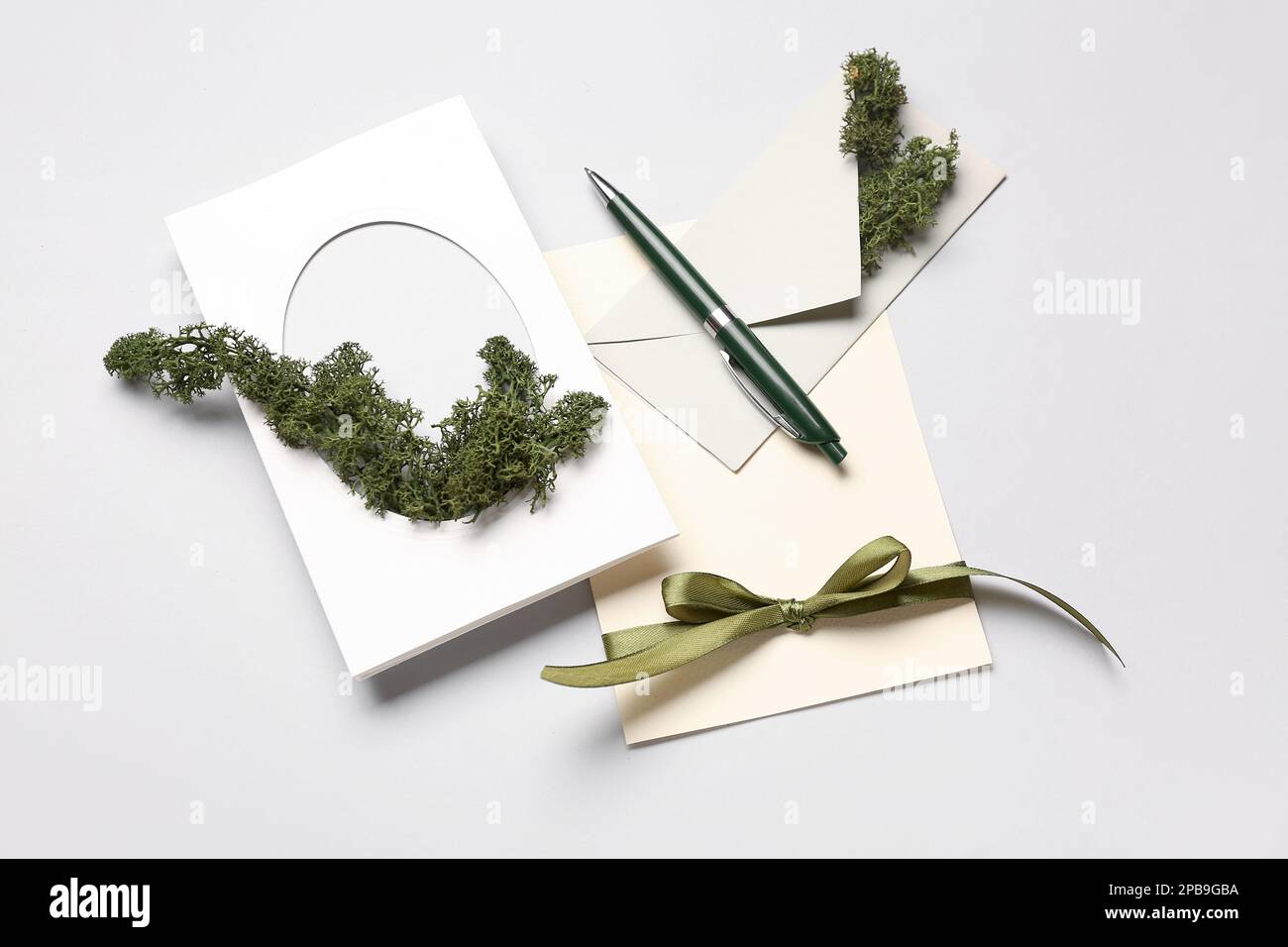 Composition with cards, envelope, pen and moss on white background ...