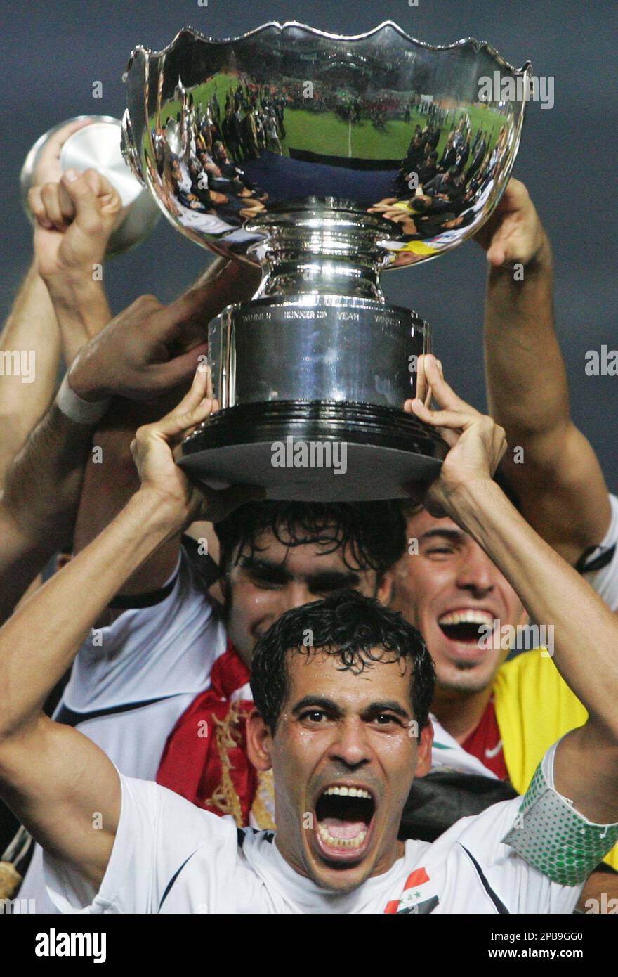 Iraq's Younis Khalef holds up the trophy as he and his teammates ...