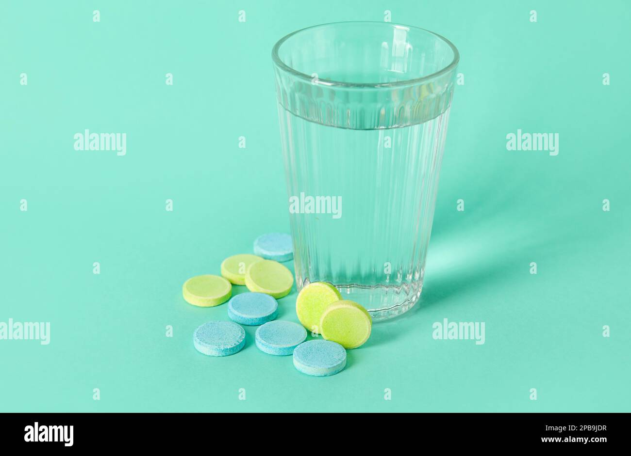 Soluble tablets and glass of water on turquoise background Stock Photo ...
