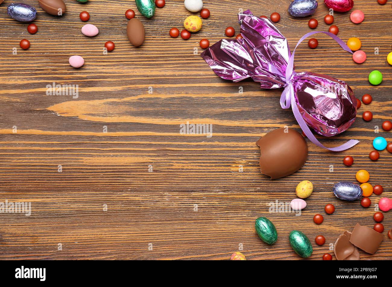 Frame made of chocolate Easter eggs and candies on brown wooden ...