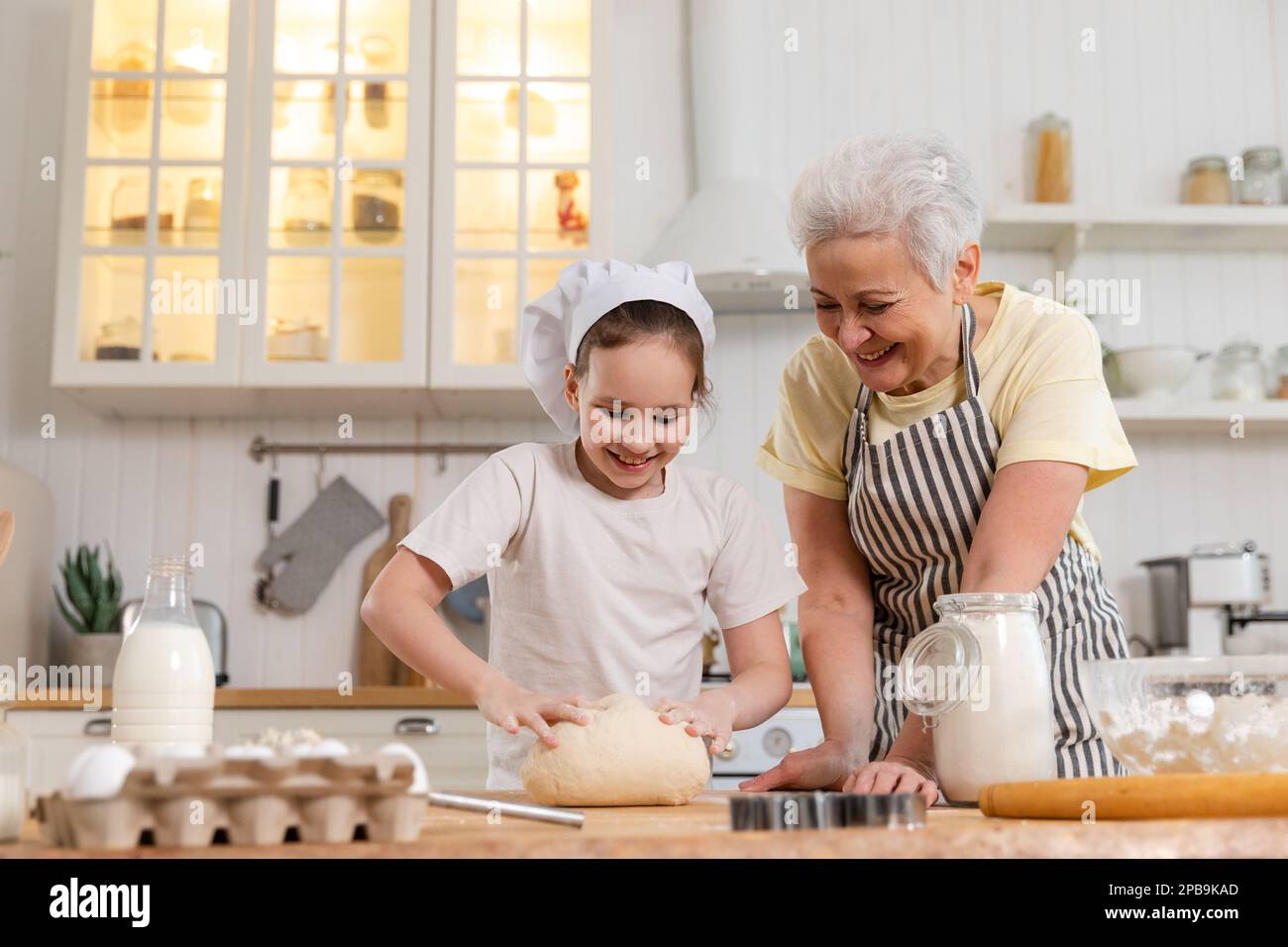 Happy family in kitchen. Grandmother and granddaughter child cook in ...