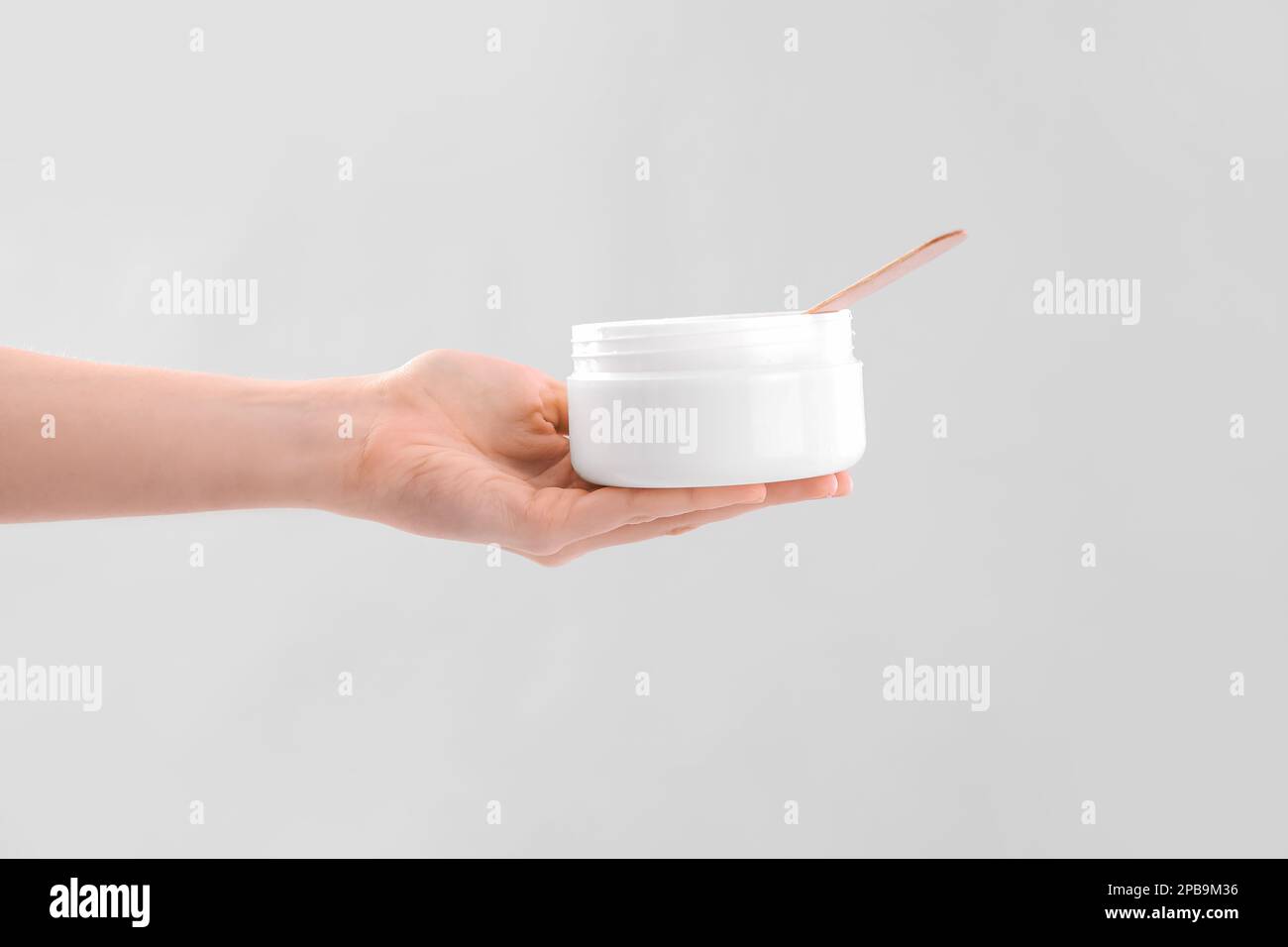 Hand with sugaring paste on light background Stock Photo - Alamy