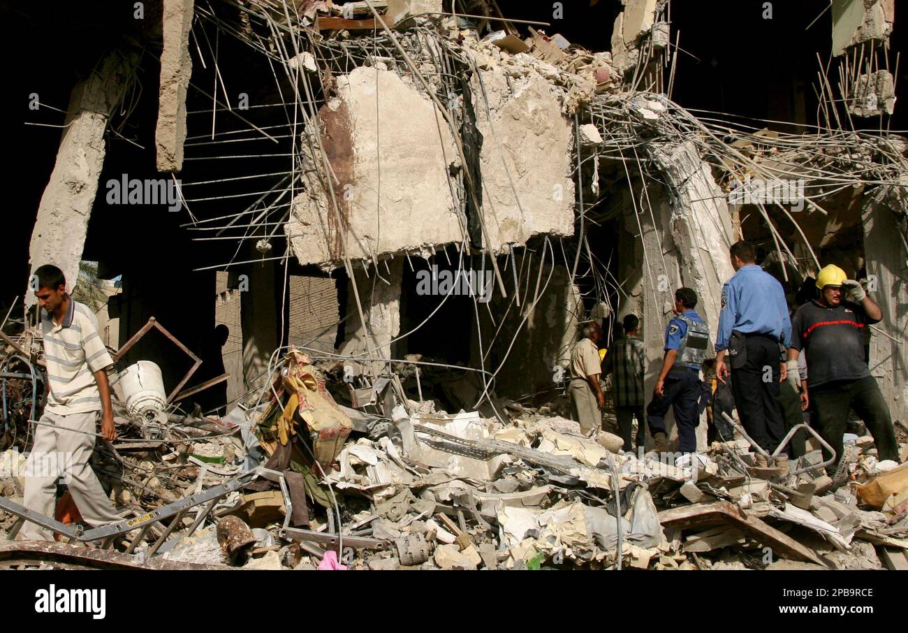 Iraqi men check the wreckage of a building that collapsed following ...
