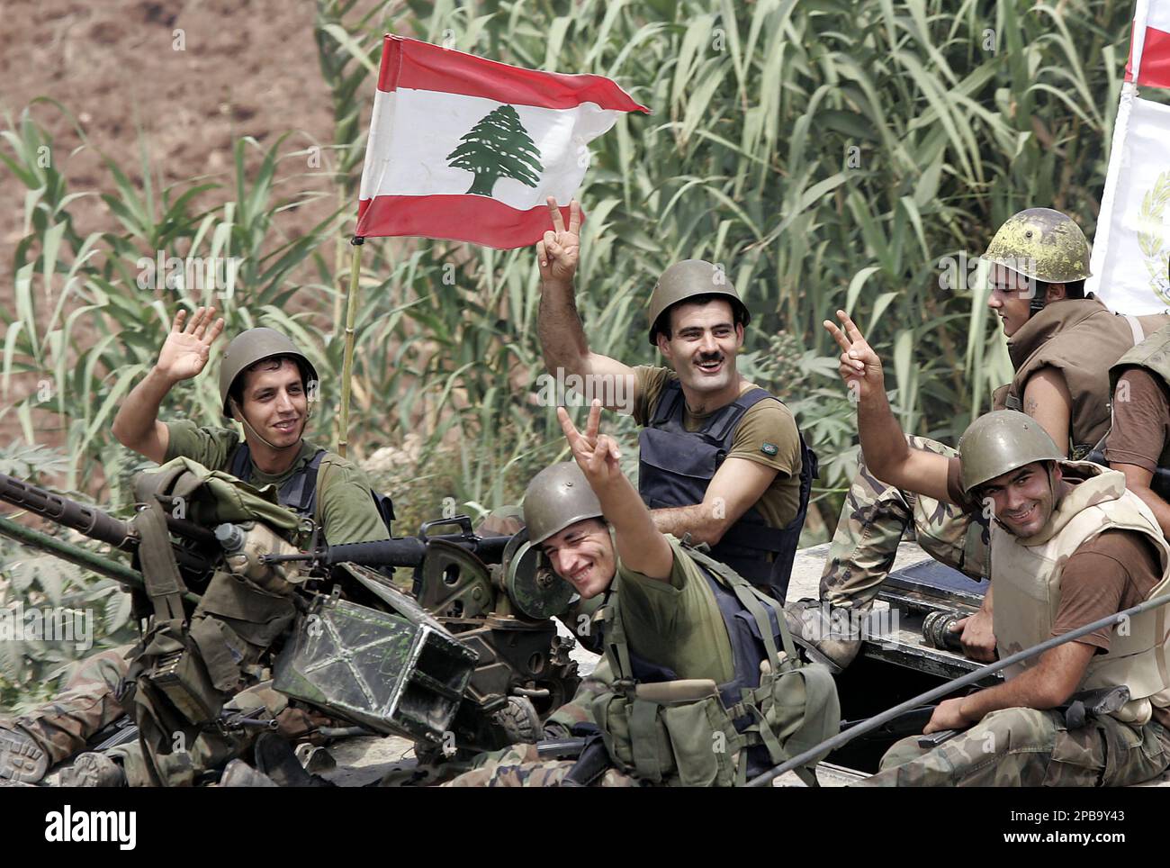 Lebanese army soldiers flash V signs as they sit on their armored ...