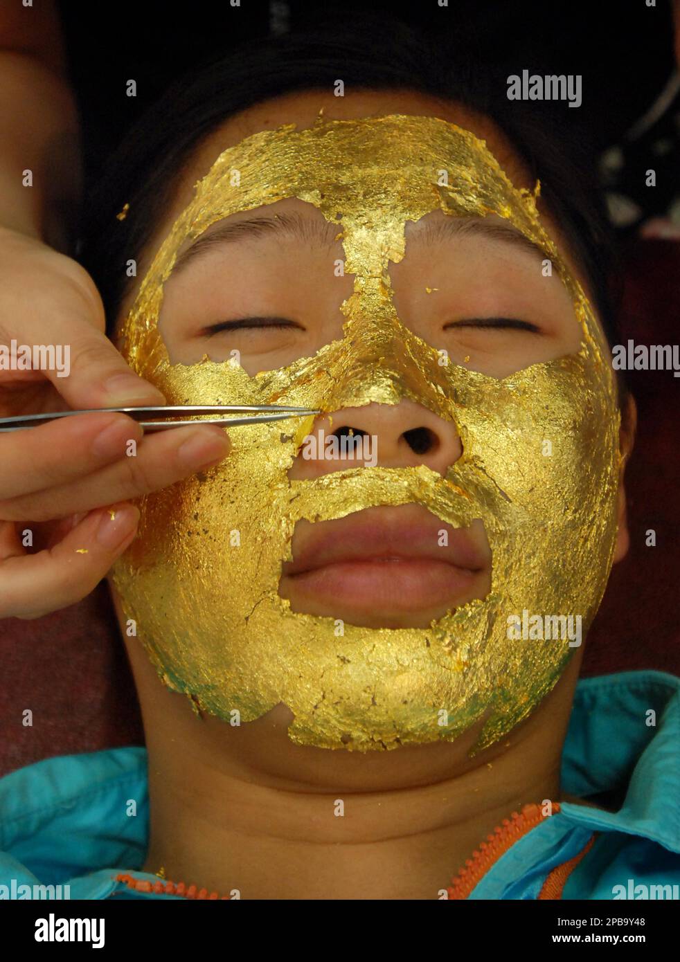 A gold facial mask, which sells for NT$3.400, US$ 105, is applied to a ...