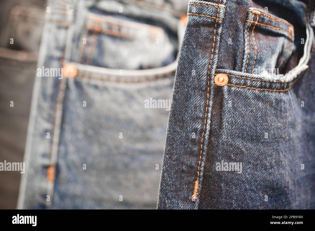 Many jeans hanging on arack. Row of pants denim jeans hanging in closet ...