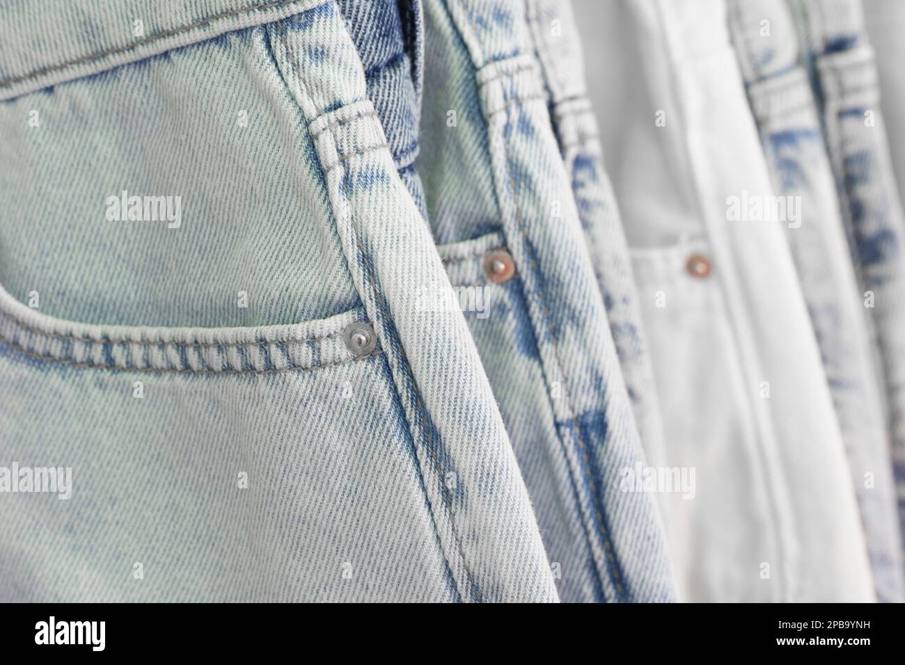 Many jeans hanging on arack. Row of pants denim jeans hanging in closet ...