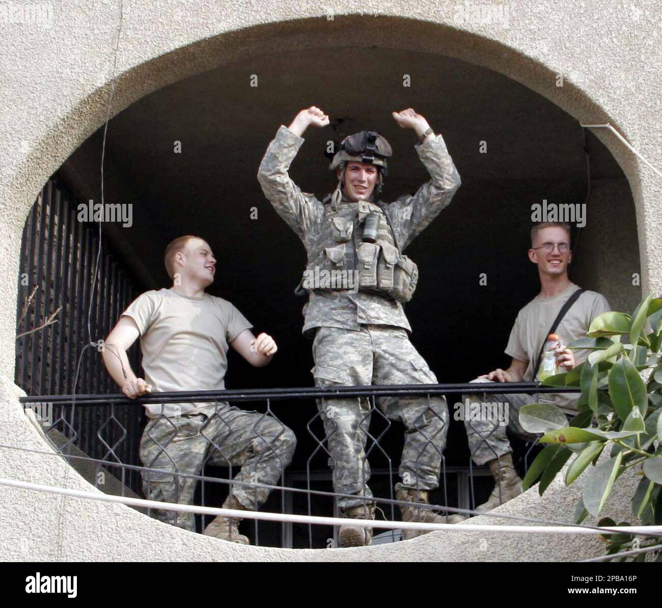 U.S. soldiers cheer on young boys celebrating outside their combat ...